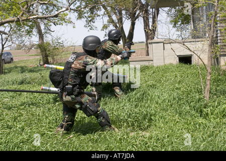 SWAT team members running towards house to break window and deploy a ...