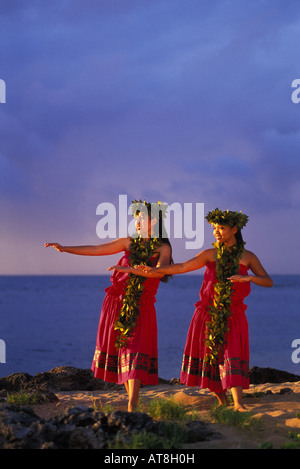 Two young women dancing kahiko (ancient) hula wearing maile leis with ...