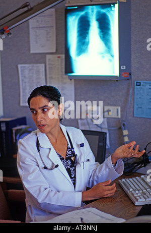 Dr Emily Cooper works at a computer in her office with an X-ray on the ...