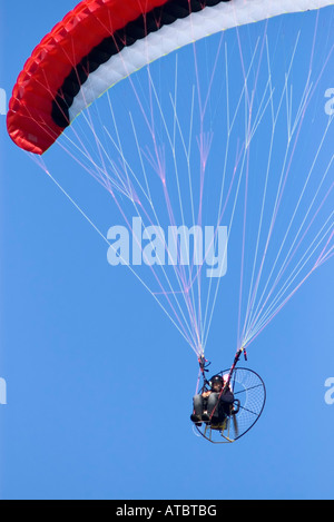 Paramotor pilot in flight in blue sky Stock Photo - Alamy