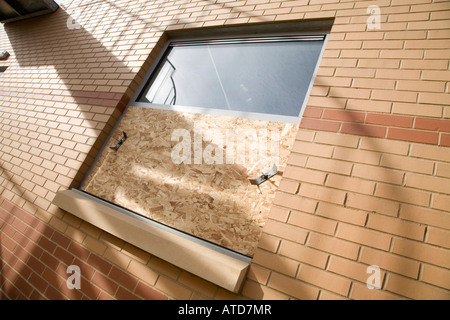 Temporary boarding up of a window broken by hooligans Stock Photo - Alamy