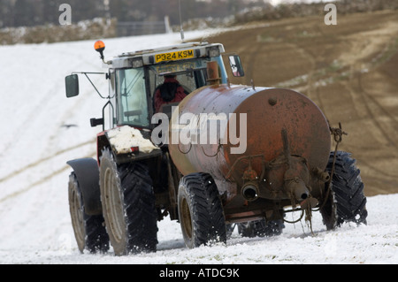 Slurry spreading over a snowy field using Massey Ferguson 6160 tractor ...