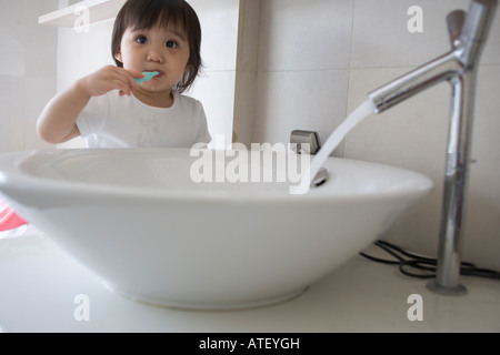 Child brushing teeth with water running Stock Photo - Alamy