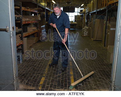 Man sweeping warehouse floor with broom Stock Photo: 50015394 - Alamy