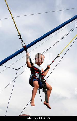 Bungee jump trampoline boy - an excited young boy practices bungee ...