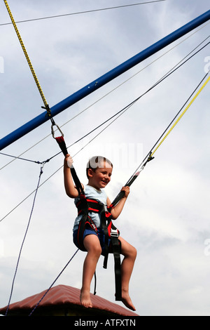 Bungee jump trampoline boy - an excited young boy practices bungee ...