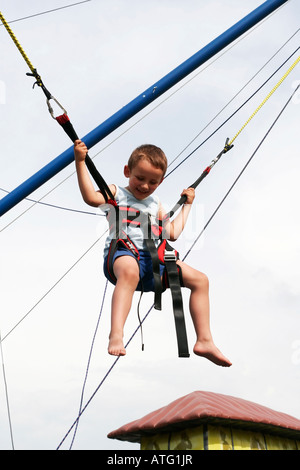 Bungee jump trampoline boy - an excited young boy practices bungee ...