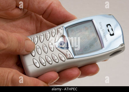 Womans fingers dialing silver Sony Ericsson mobile phone Stock Photo ...
