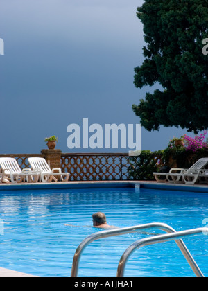 A thunderstorm approaching over a swimming pool of a tourist hotel in ...