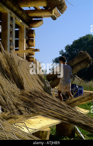 Man carrying straw bolts used for straw roof of slovak traditional ...