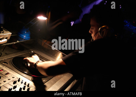 Club DJ Cutting in a Track on a Turntable Behind the Decks of a ...