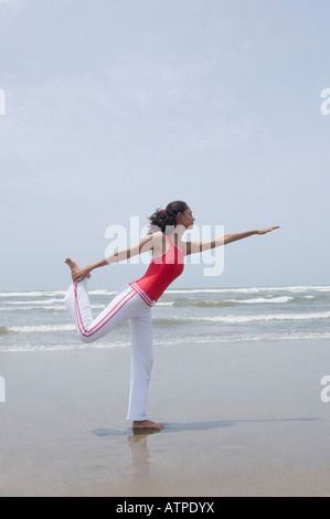 Side view of woman practicing yoga in the mountains. Female is ...