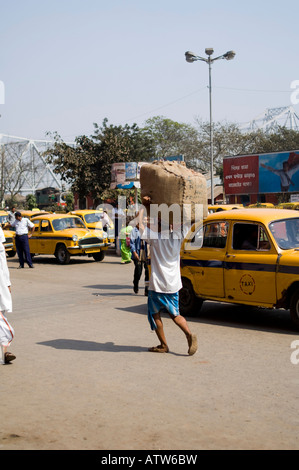 A porter carrying a load on his head enters Chhatrapati Shivaji Maharaj ...