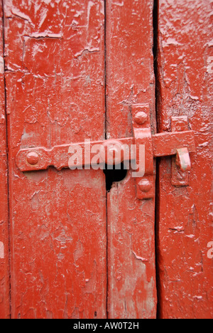 Red-oxide painted door latch on old agricultural building Stock Photo ...