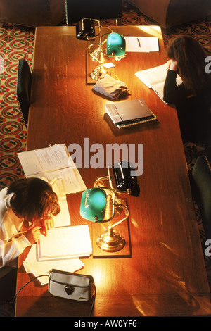 Two university students sitting at desk studying, with laptop ...