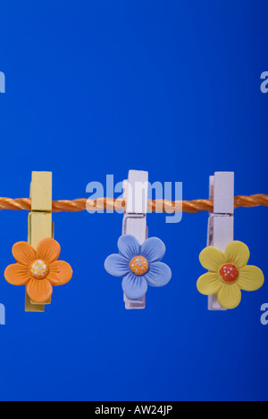 Wooden flower decorated pegs on a clothesline Stock Photo - Alamy