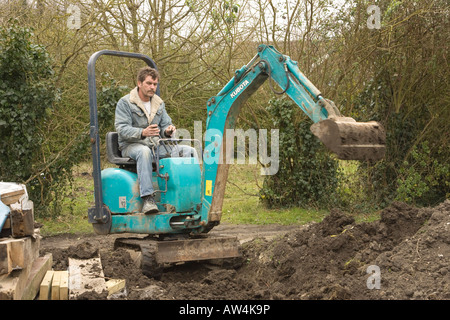 a man driving a mini digger / excavator Stock Photo - Alamy