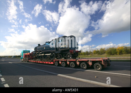 Steam locomotive train being transported by road on a low loader Stock ...