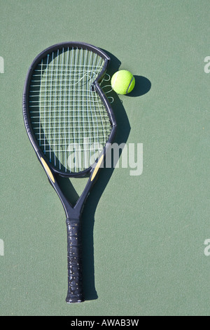 Broken tennis racket on green court with tennis ball Stock Photo - Alamy