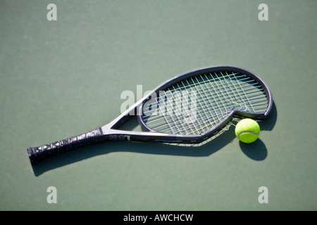 Broken tennis racket on green court with tennis ball Stock Photo - Alamy