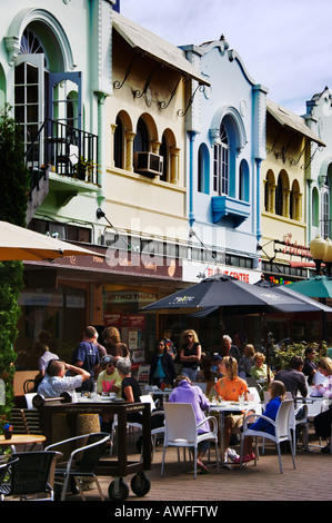 A cafe scene below Spanish Mission style architecture in New Regent ...