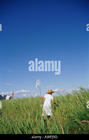 Boy catching insects in field Stock Photo - Alamy