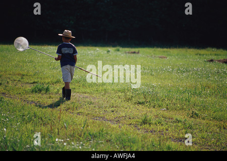 Boy catching insects in field Stock Photo - Alamy