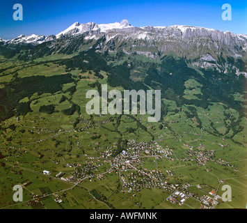 An aerial shot of a mountain range covered with green plants with a ...