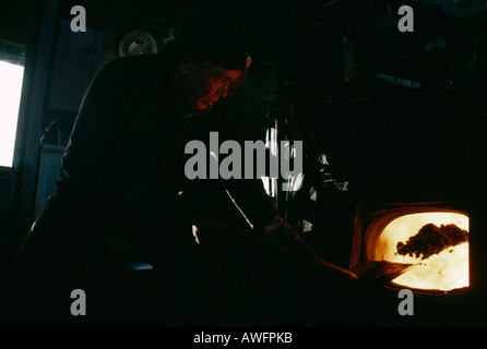 Russian train driver shovelling coal into the firebox of a Type L steam ...
