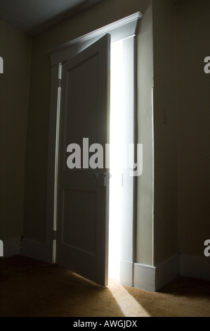 Door slightly open exposing bright light Stock Photo - Alamy
