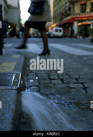 Crosswalk water pouring into gutter Stock Photo - Alamy