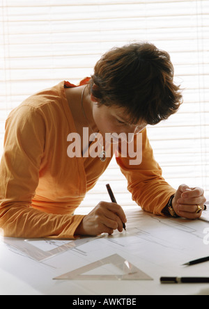 Woman bending over table, holding set square and pen Stock Photo - Alamy