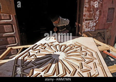 Carpenter making a huge star-shaped ornament, street workshop ...