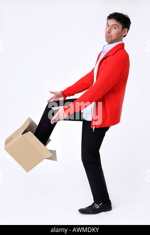Man climbing into a small cardboard box Stock Photo - Alamy