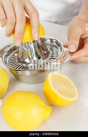 Female hand squeezing lemon on marinated steak in glass dish Stock ...