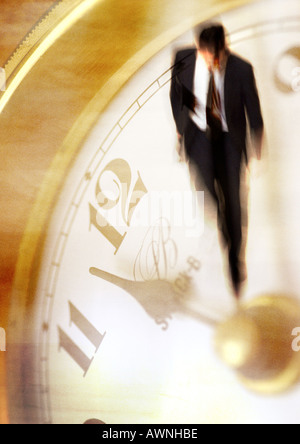 Businessmen walking on clock, montage Stock Photo - Alamy