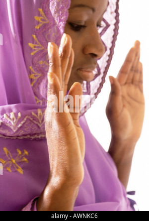 Muslim woman in a veil holding prayer beads and the Quran on the mosque ...