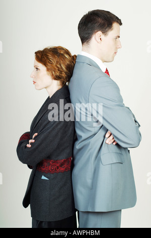 A man with dark hair stands with his back to the camera, wearing a gray ...