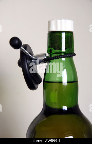 A security tag on a full whisky bottle Stock Photo - Alamy
