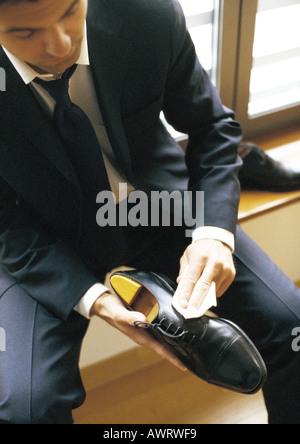 Young man polishing shoe Stock Photo - Alamy