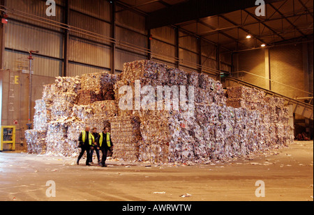 Paper mill. Workers with bales of waste paper to be recycled for paper ...