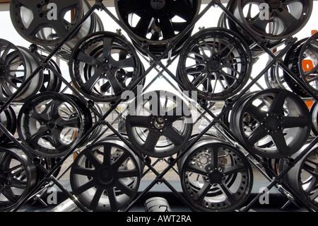 Designer alloy aluminium car wheels stacked on a metal rack in a shop ...