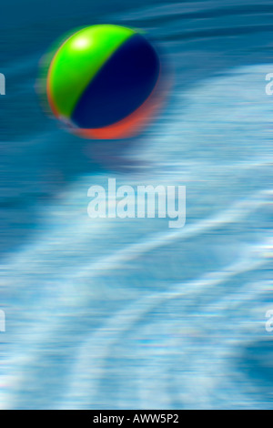 Colorful beach ball floating on water of swimming pool Stock Photo - Alamy