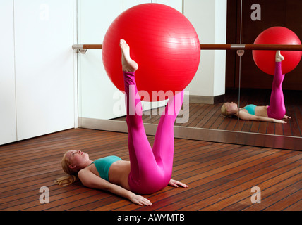 Young woman exercise with red pilates ball isolated on white Stock ...