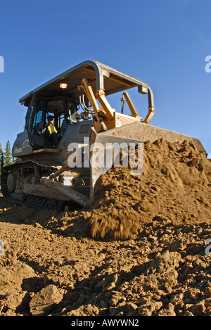 Earth moving and ground leveling work using heavy equipment at a ...