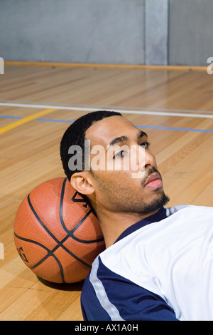 Single basketball lying on basketball court with sports clothes and ...
