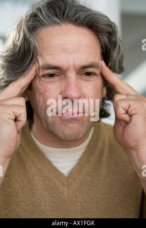 Close-up of man rubbing temples with eyes closed Stock Photo - Alamy