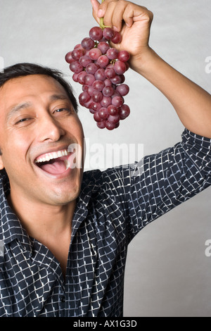 Portrait Latino man eating grapes Stock Photo - Alamy
