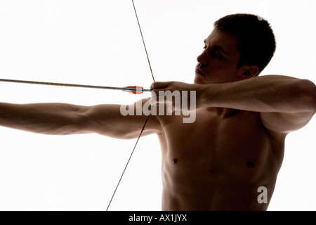 Silhouette of archer pulling an arrow back on his longbow Stock Photo ...