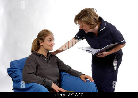 Staff sister with seated patient Stock Photo - Alamy